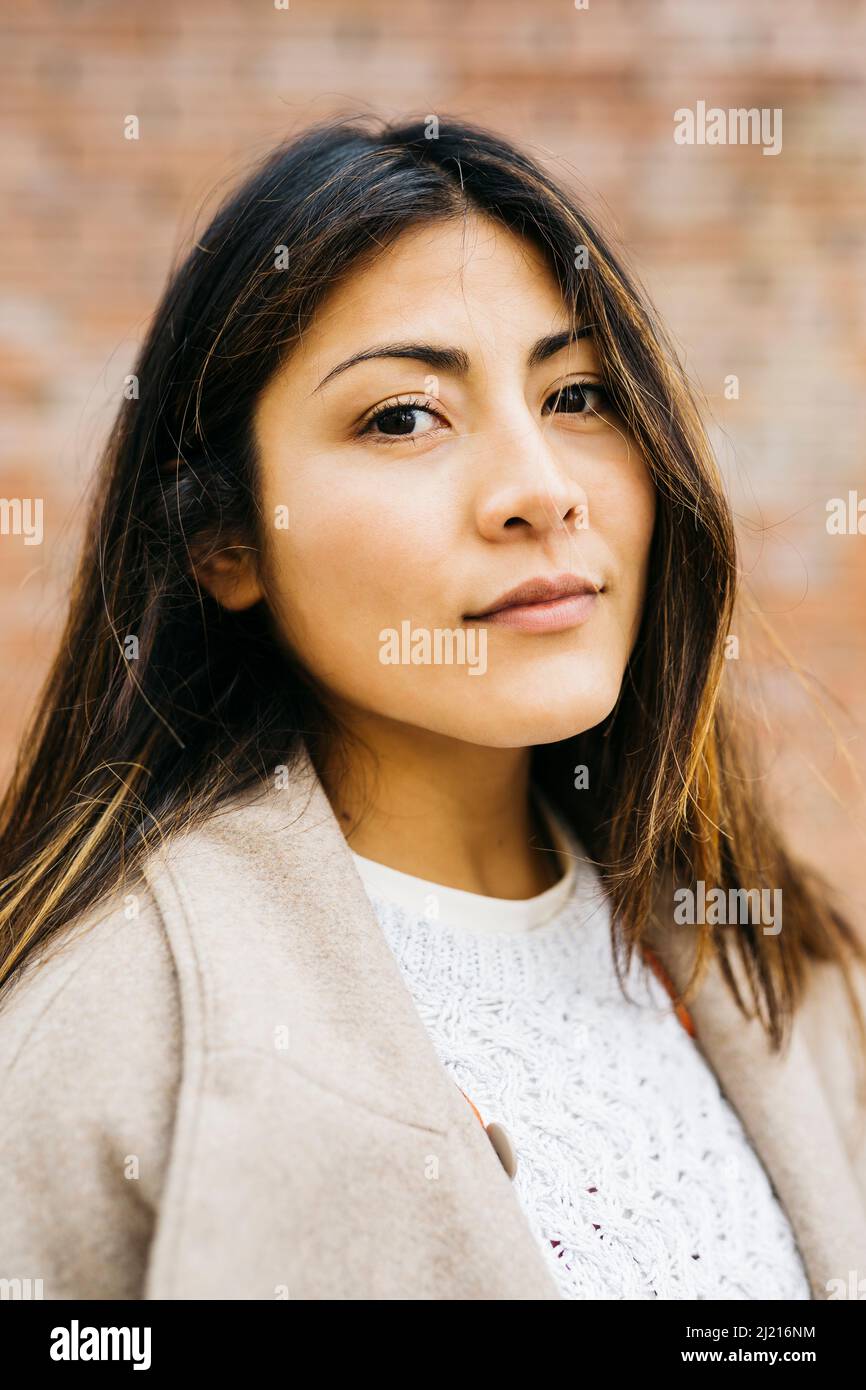 Portrait of a young woman against a brick wall Stock Photo - Alamy