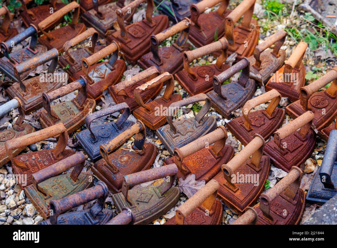 A collection of rusting, vintage old-fashioned flat irons (or sad irons ...
