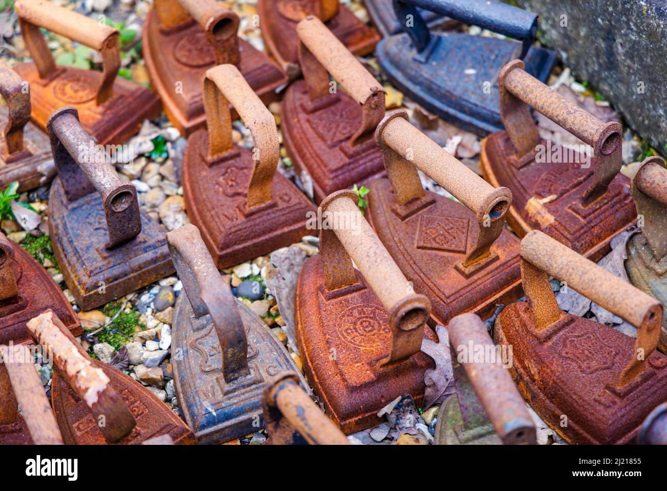 A collection of rusting, vintage old-fashioned flat irons (or sad irons ...