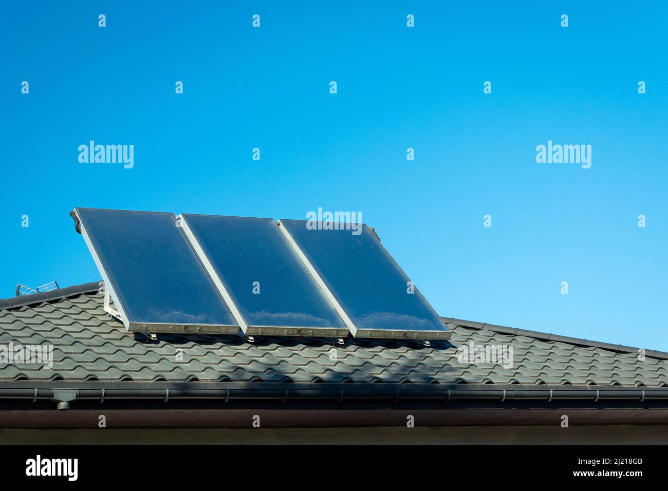 Three solar panels mounted on the roof and blue sky Stock Photo - Alamy