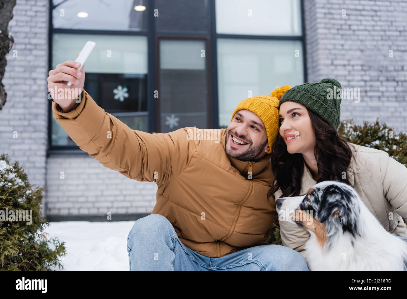 happy man in knitted hat taking selfie with girlfriend and australian ...