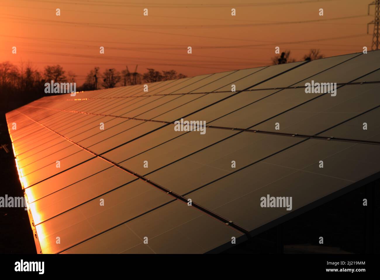Sunset rays over photovoltaic power plant. Solar panels, solar farm ...