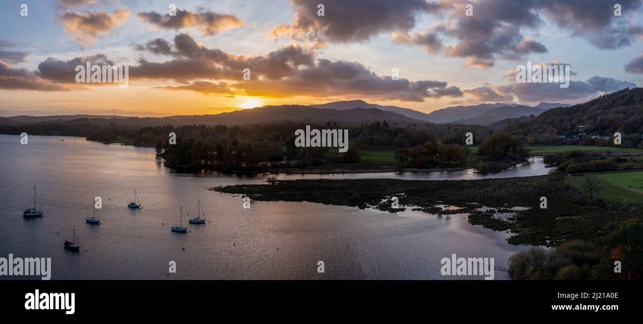 elevated panoramic view of sunset over lake windermere with boats at ...