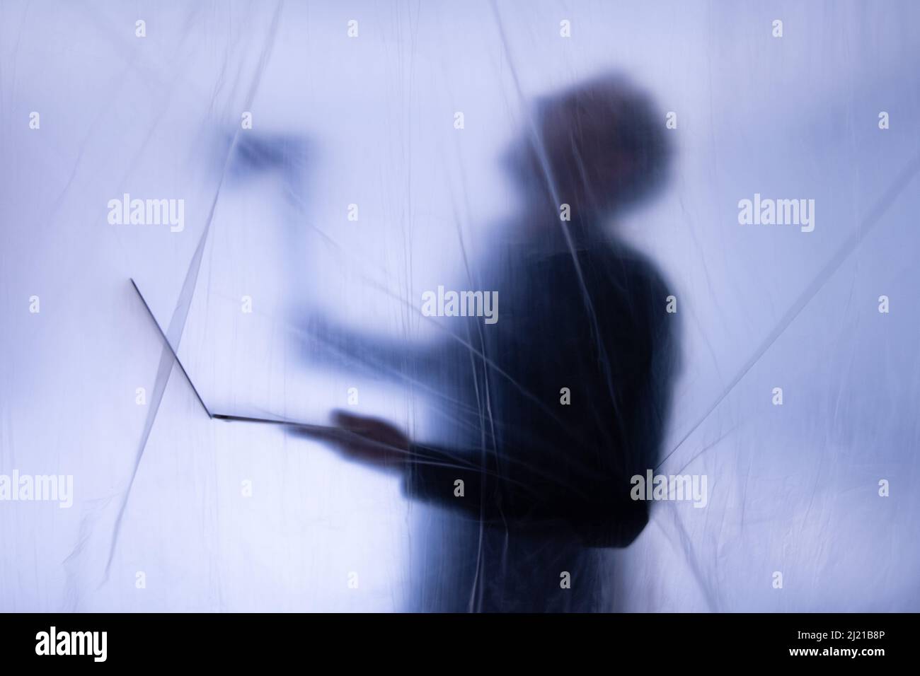 Anonymous Hacker commits cyber crime with notebook in hand. An axe is ...