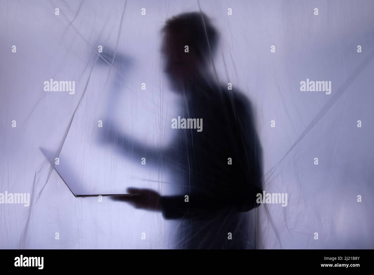 Anonymous Hacker commits cyber crime with notebook in hand. An axe is ...