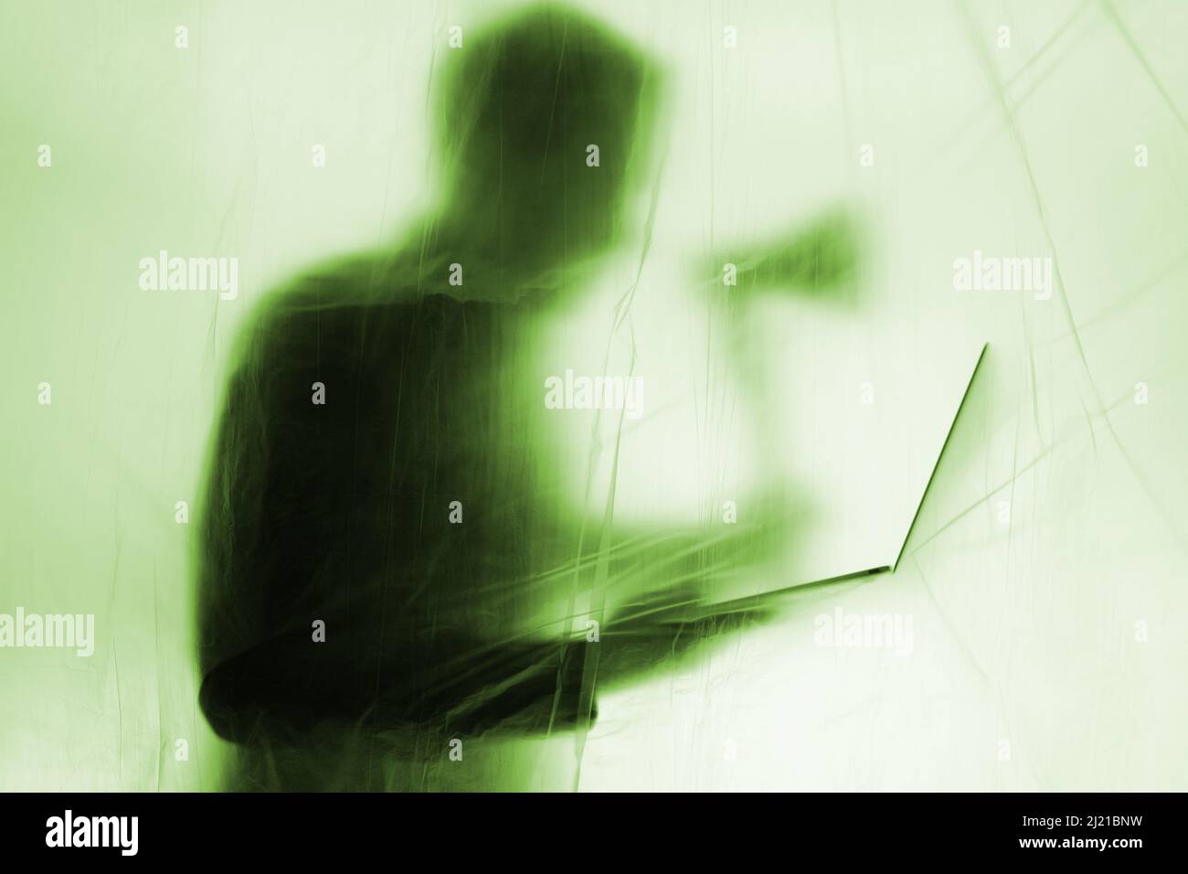 Anonymous Hacker commits cyber crime with notebook in hand. An axe is ...