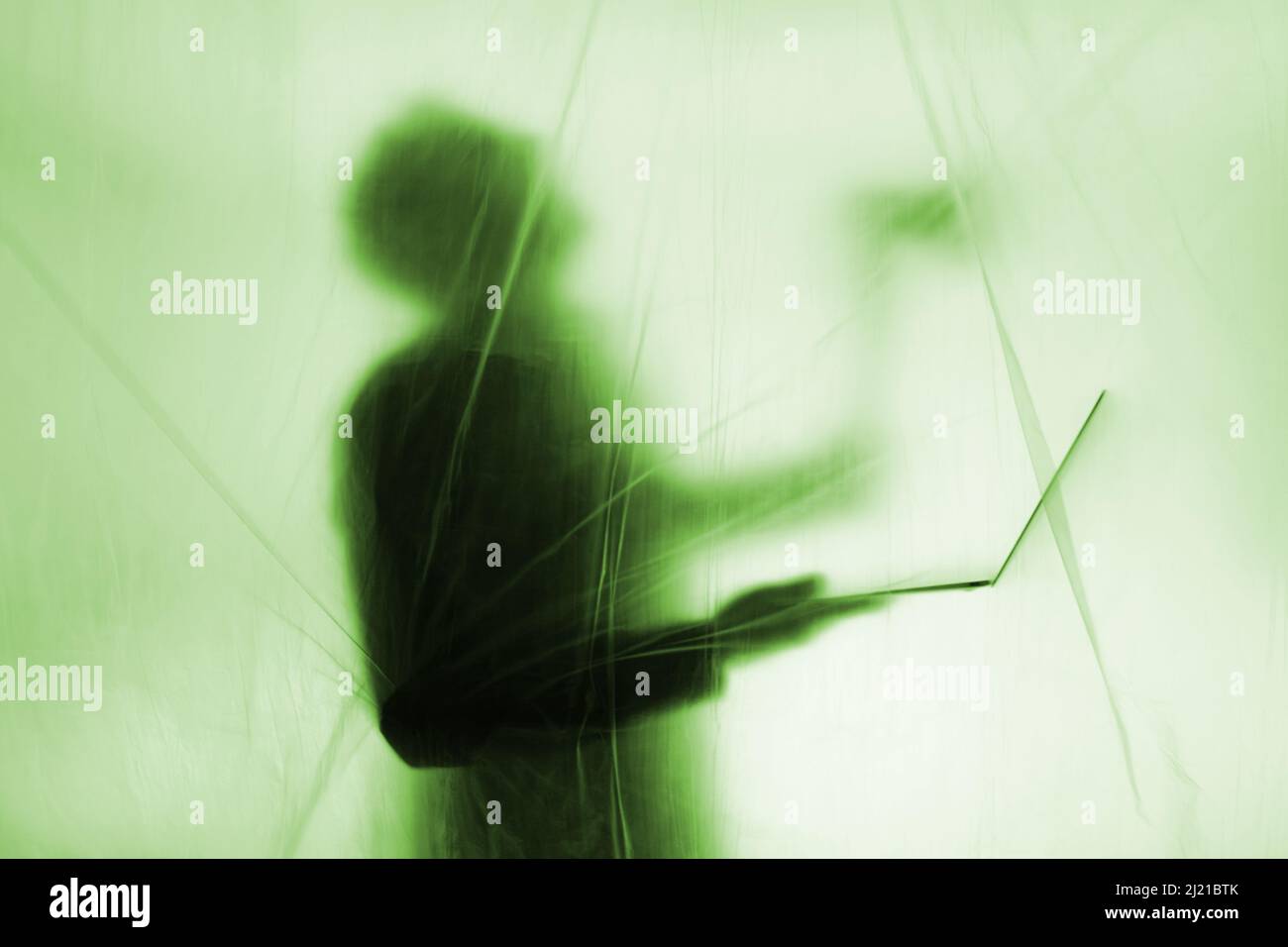 Anonymous Hacker commits cyber crime with notebook in hand. An axe is ...