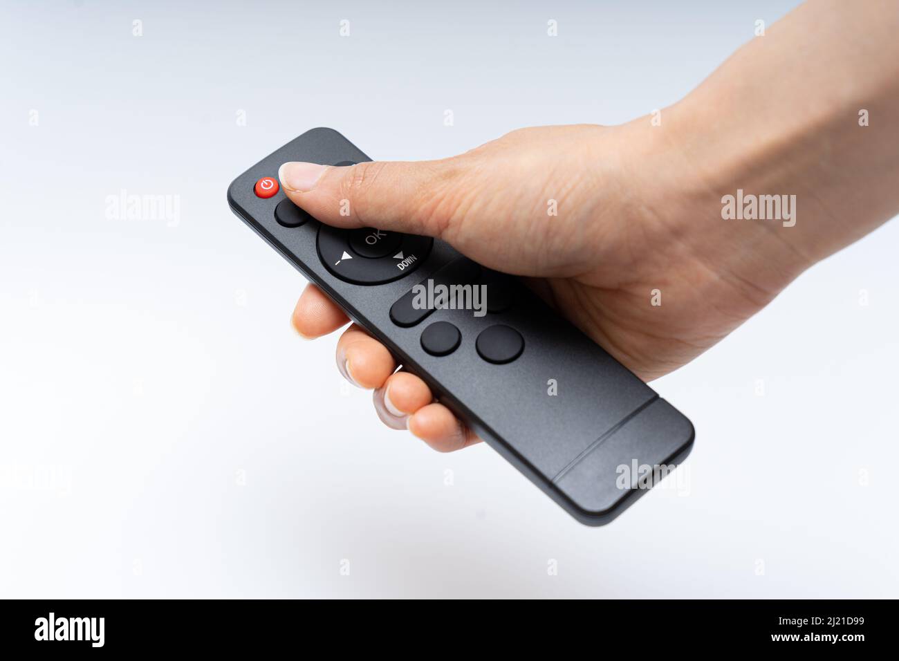 Asian hand operating remote control on white background Stock Photo - Alamy