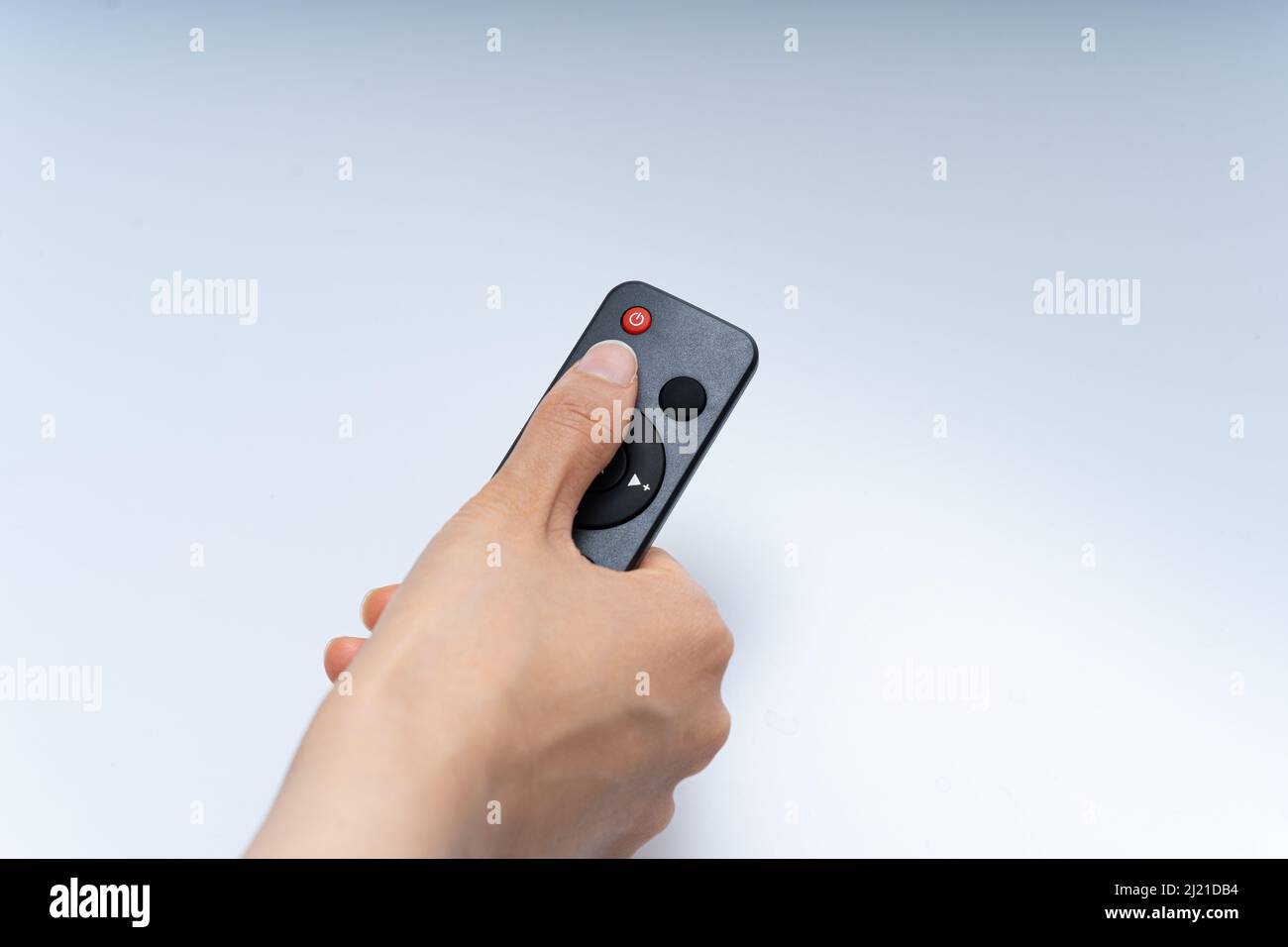 Asian hand operating remote control on white background Stock Photo - Alamy
