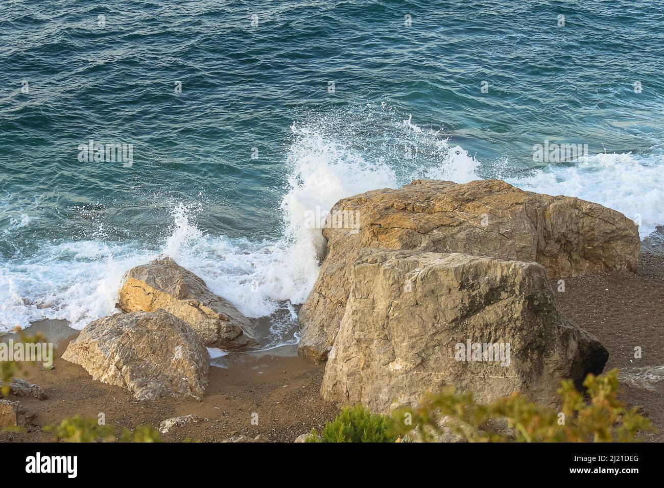 Seascape. Large boulders of stone lie on the sandy beach. The wave of ...