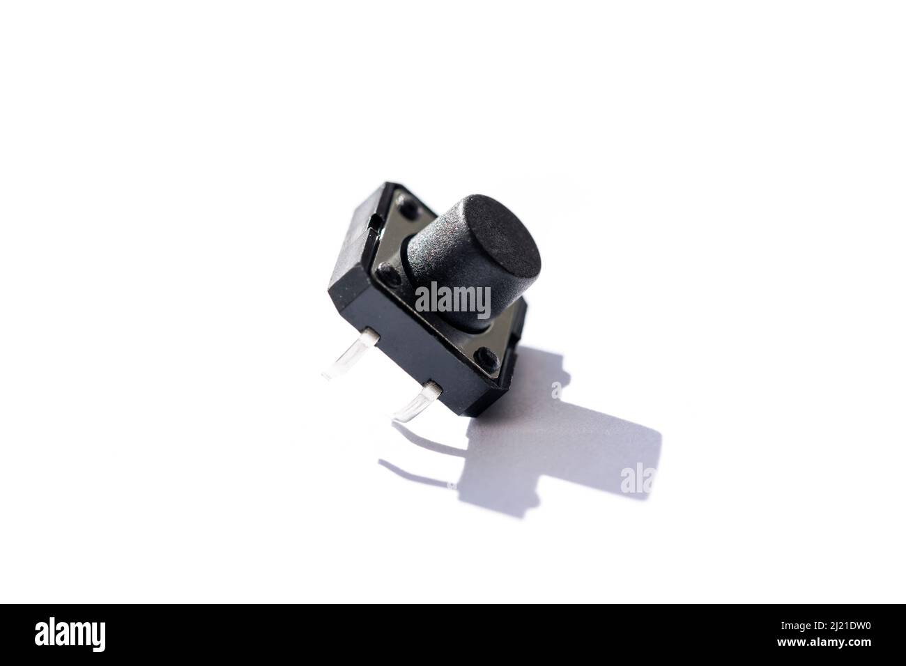 A close up portrait of a small push button. The electric component is ...