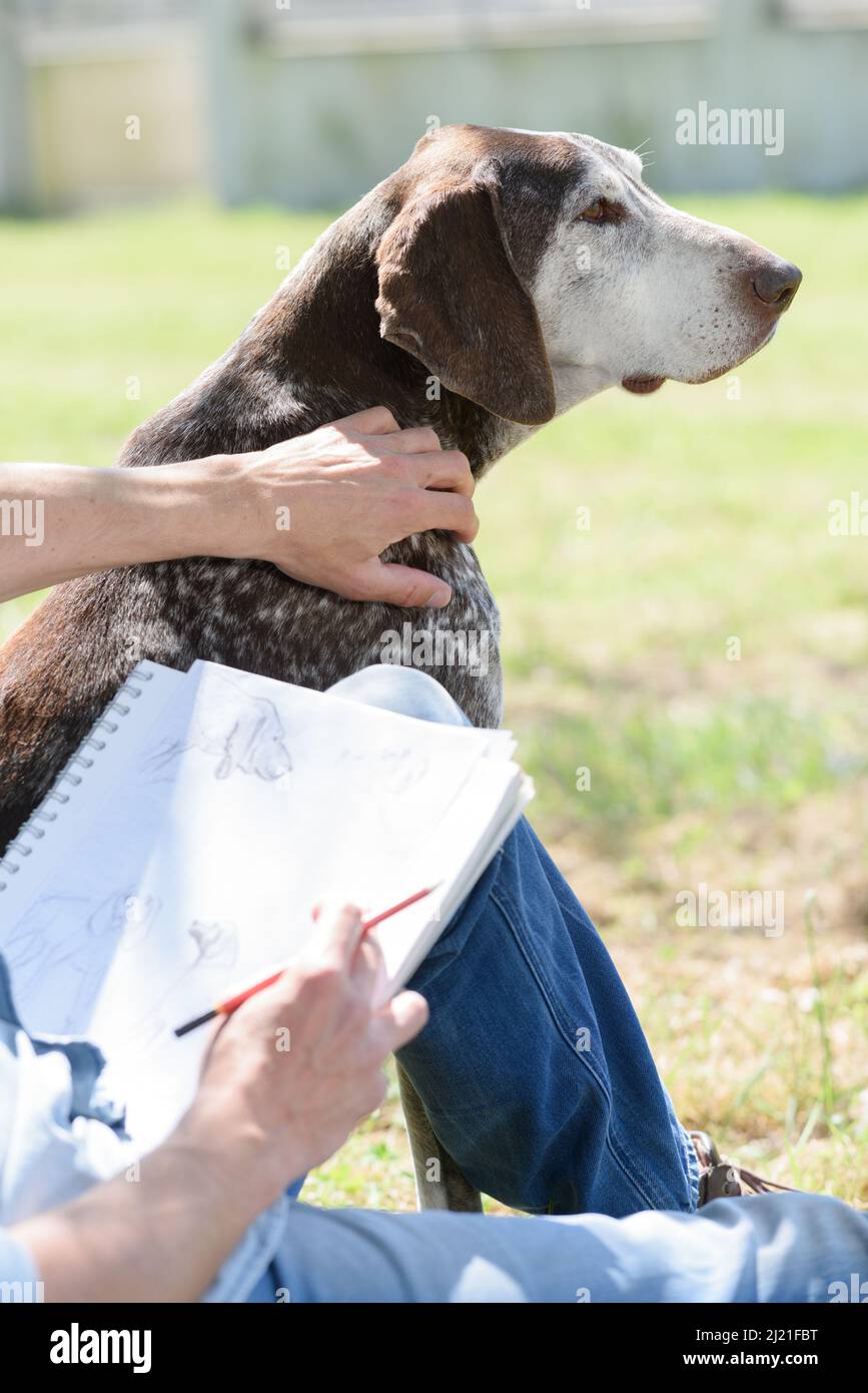 male artist sketching picture of his dog Stock Photo - Alamy