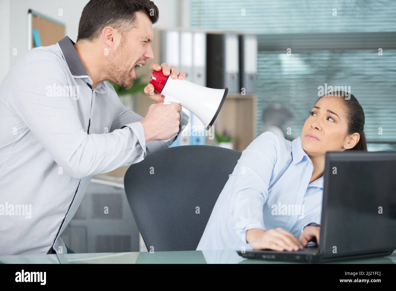 angry boss with megaphone screaming at employee in office Stock Photo ...