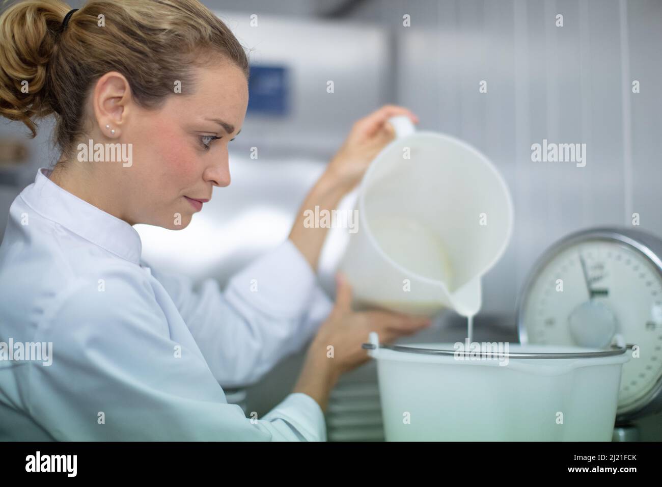 female pastry chef pouring sauce into bucket Stock Photo - Alamy