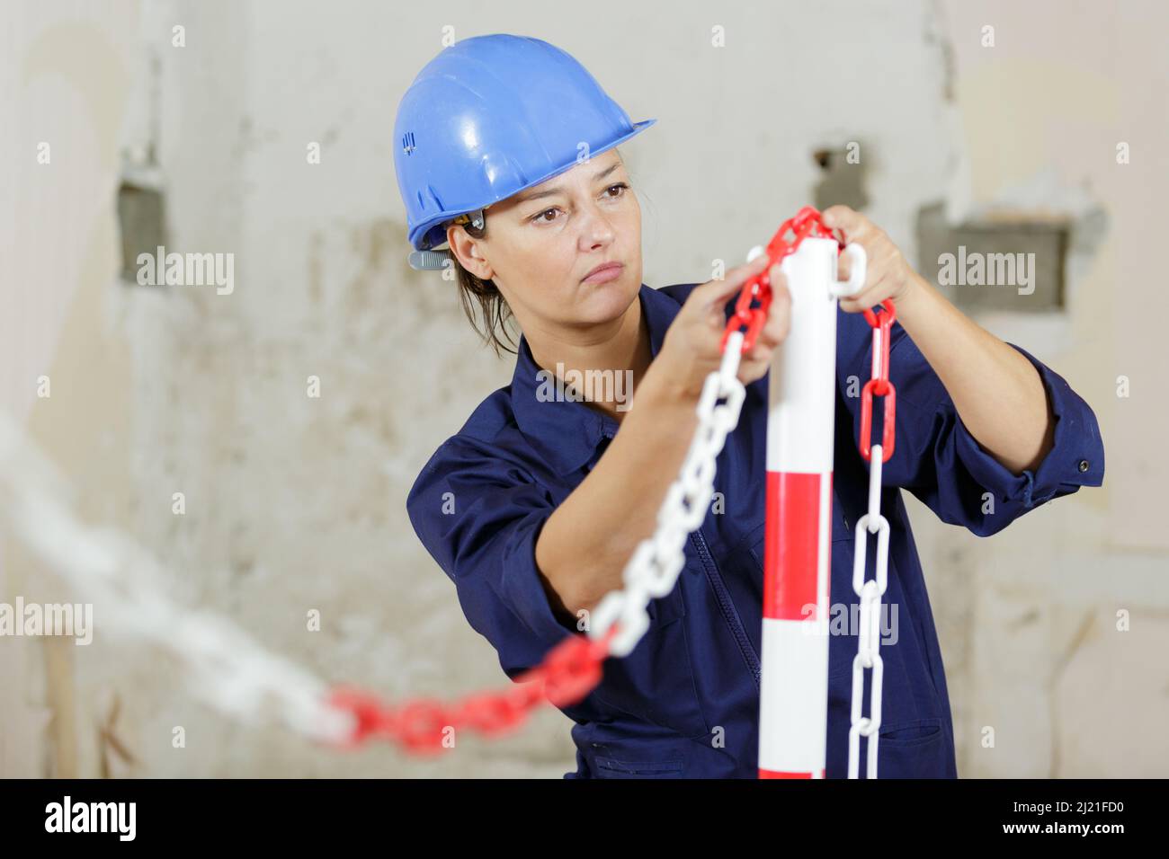 woman builder in safety helmet fitting chains in site Stock Photo - Alamy