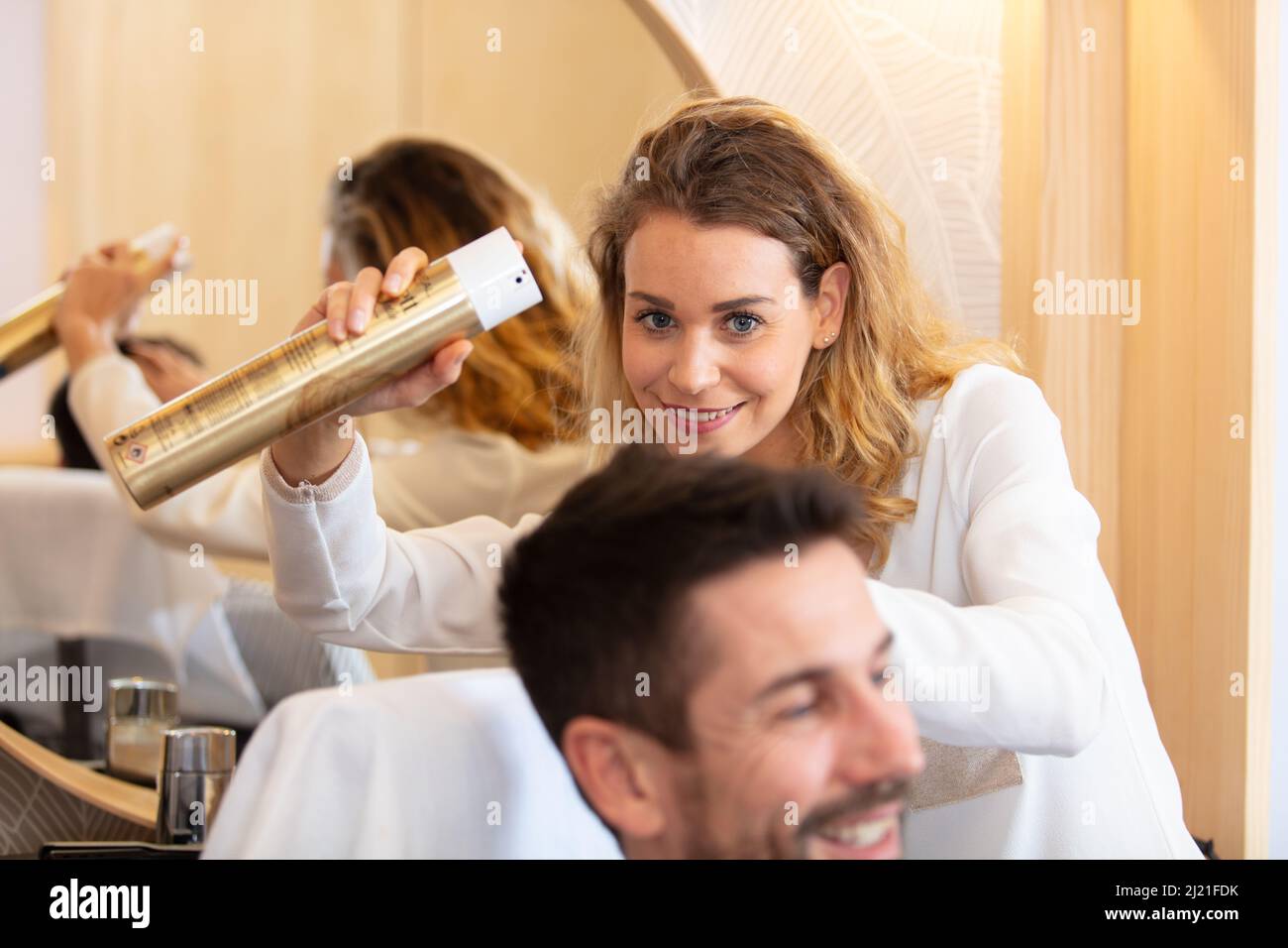 young female hairdresser applying spray on client Stock Photo - Alamy