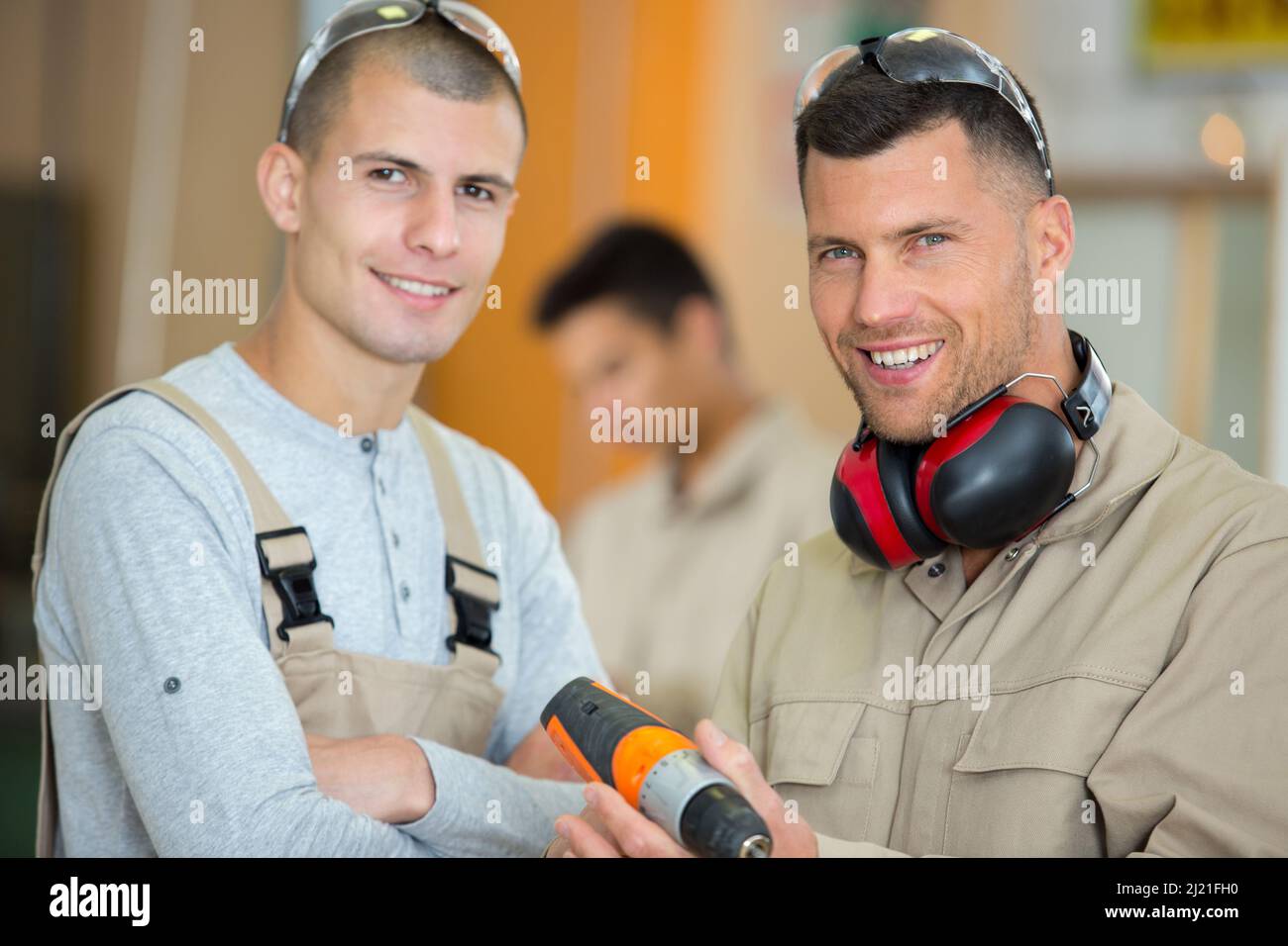 craftsman with apprentice holding drill Stock Photo - Alamy