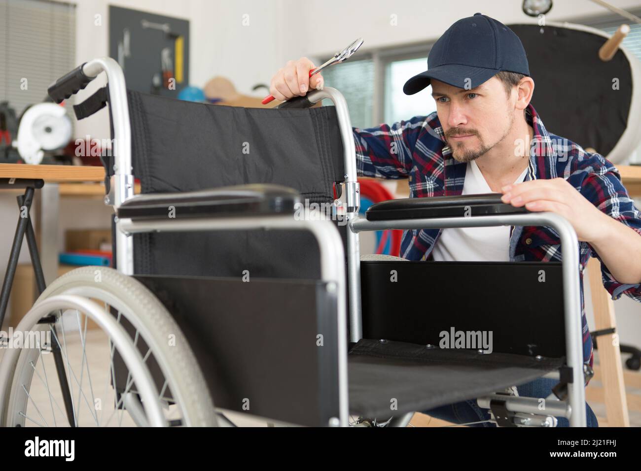 disabled man repairing wheelchair at workshop Stock Photo - Alamy