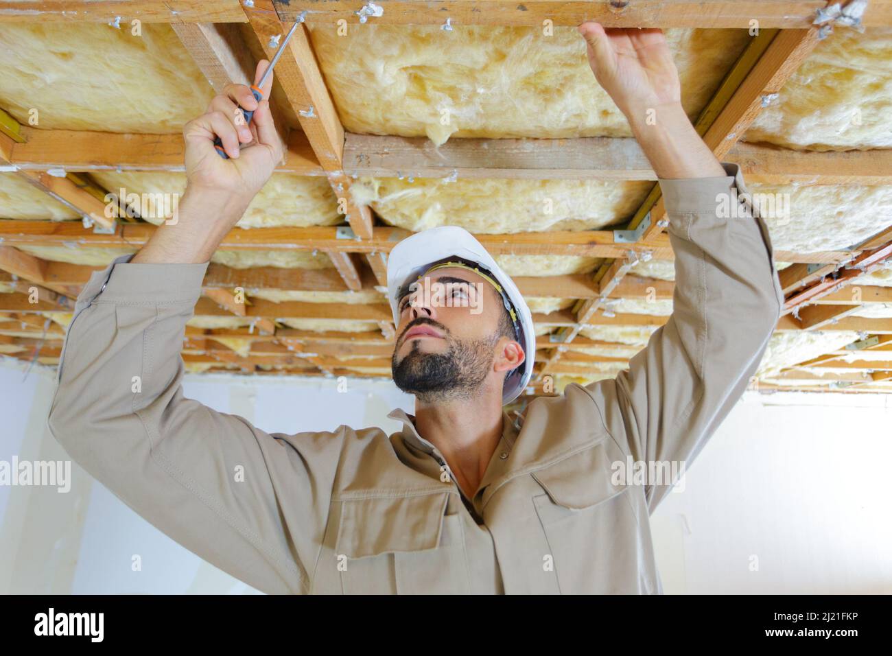a construction worker fixing ceiling Stock Photo - Alamy