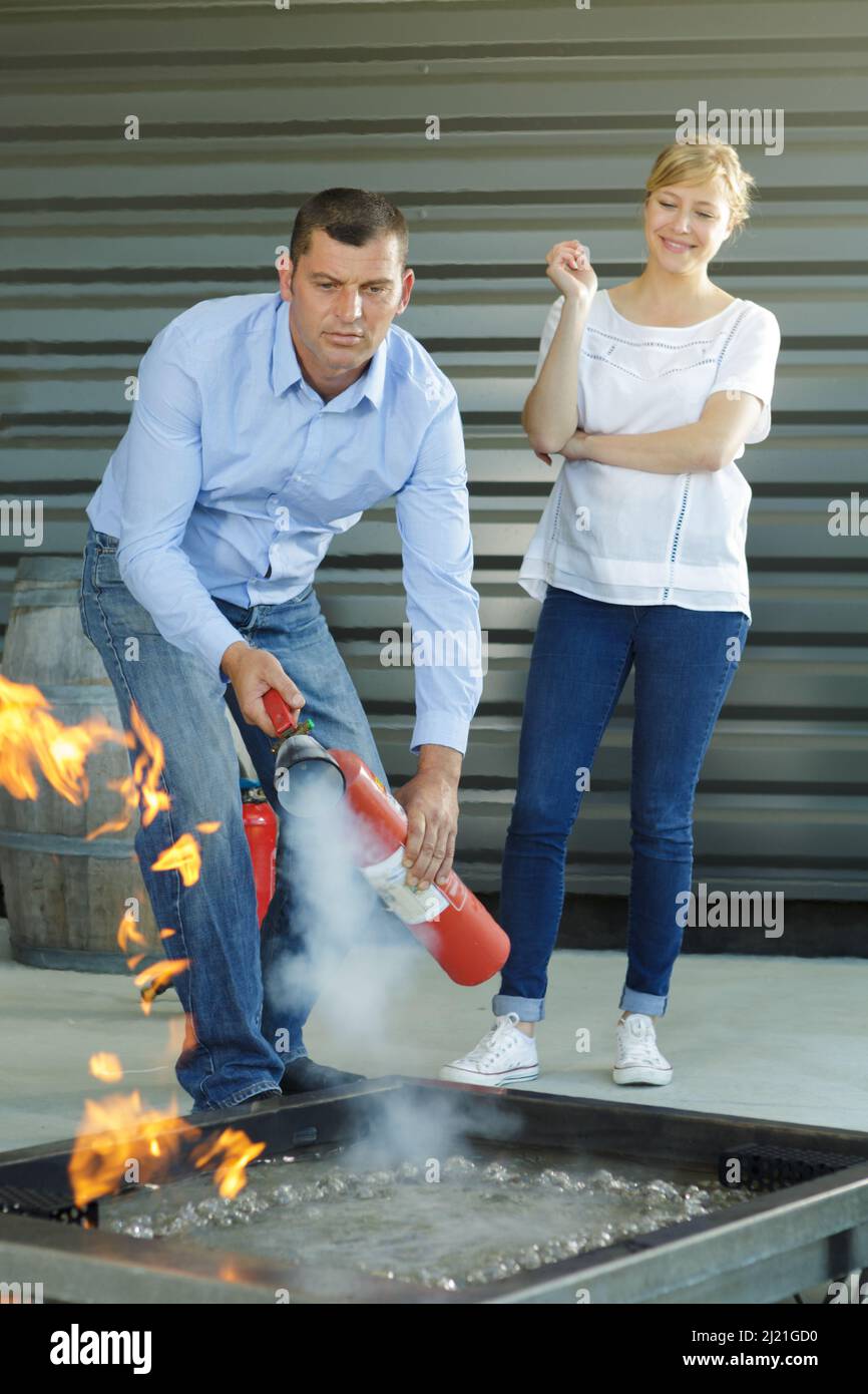 man and woman trying fire extinguisher Stock Photo - Alamy