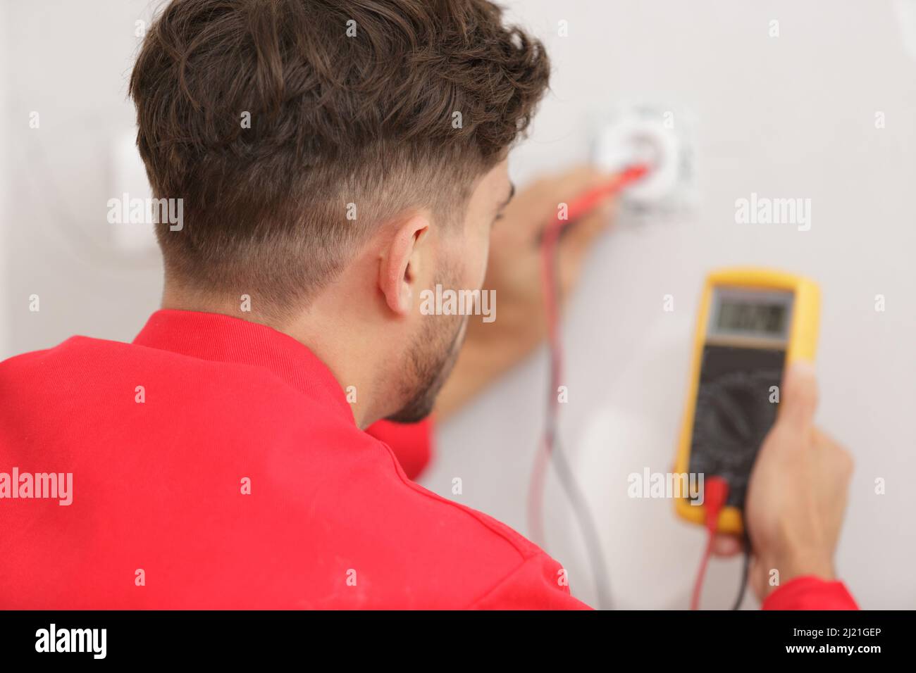 male hands measuring voltage in electrical wall recepticle Stock Photo ...