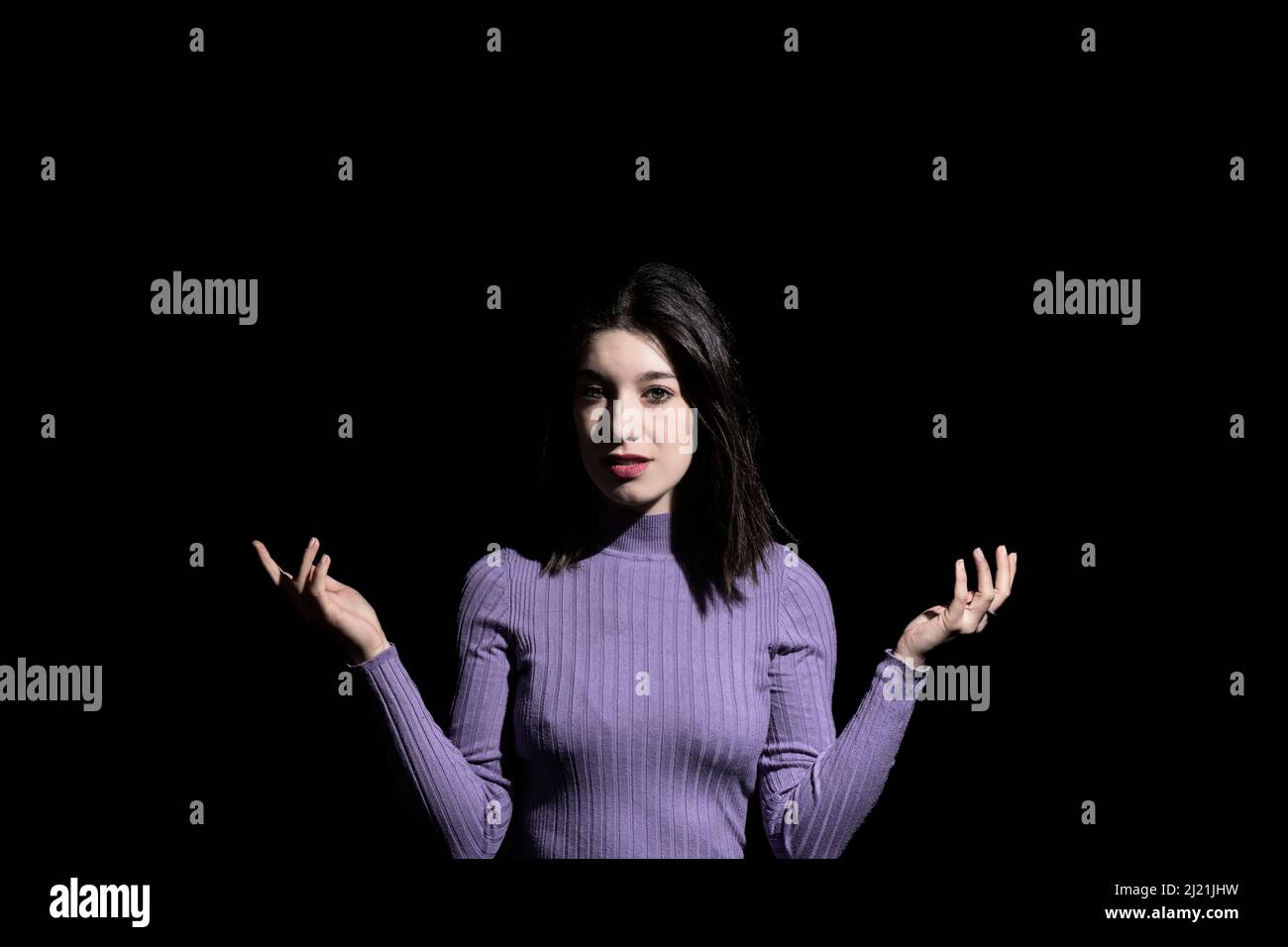 brunette woman on black background with doubt gesture Stock Photo - Alamy