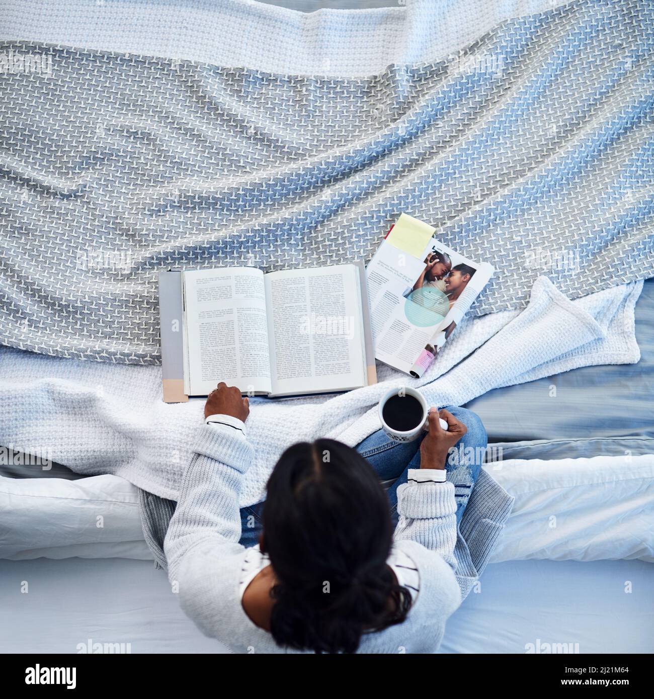 Relaxing with a good read. High angle shot of an unrecognizable woman ...