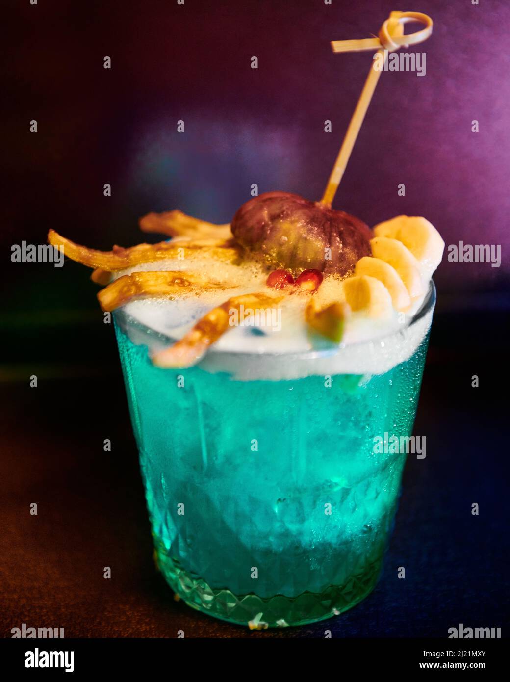 A blue cocktail featuring a sea monster garnish Stock Photo - Alamy