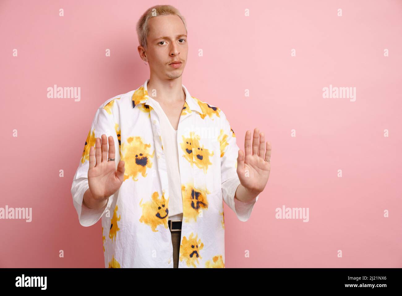 Young blonde man making stop gesture and looking at camera isolated ...
