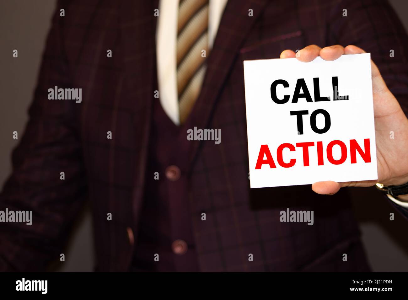 Closeup on businessman holding a card with text CALL TO ACTION ...