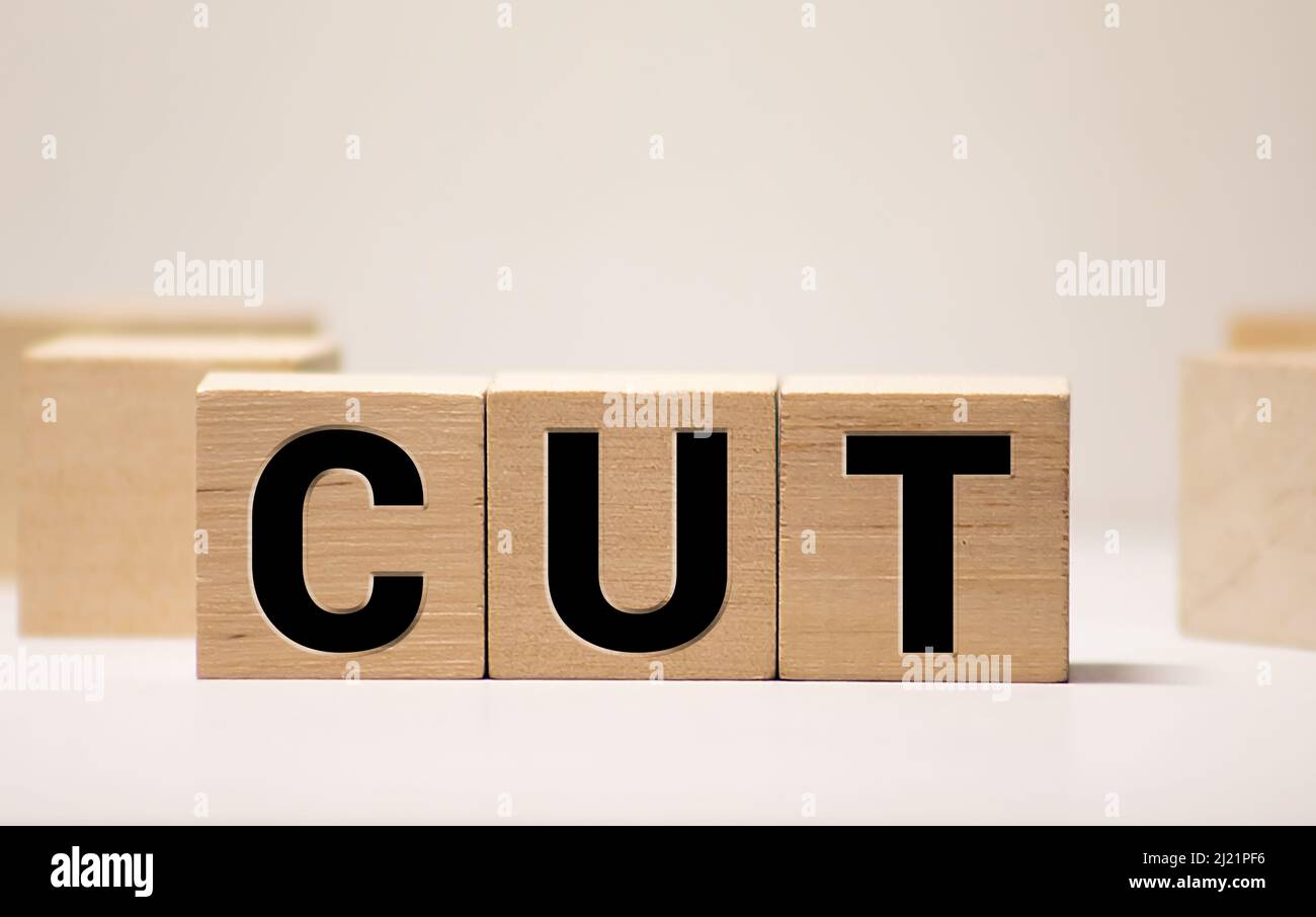 Small cube block with word cut on banknote of US dollar background ...