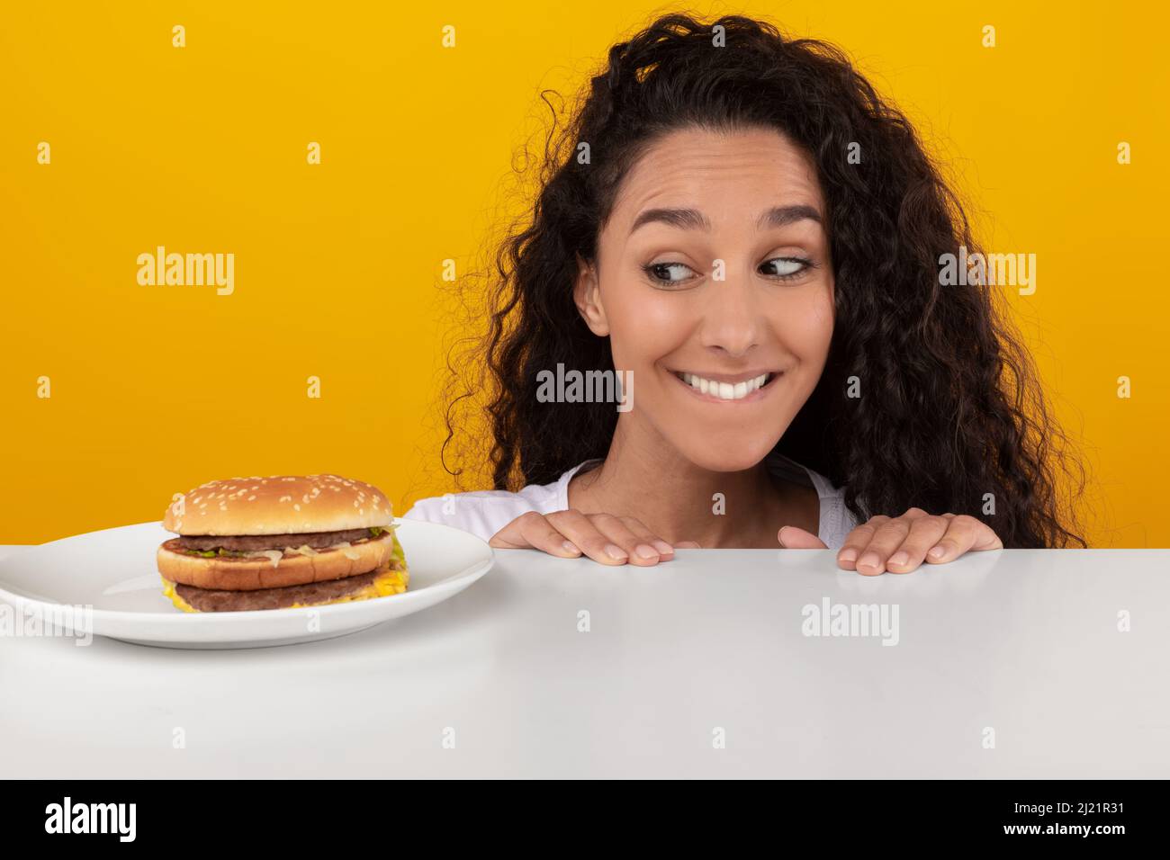Hungry Lady Looking At Burger Peeping Out Table Stock Photo - Alamy
