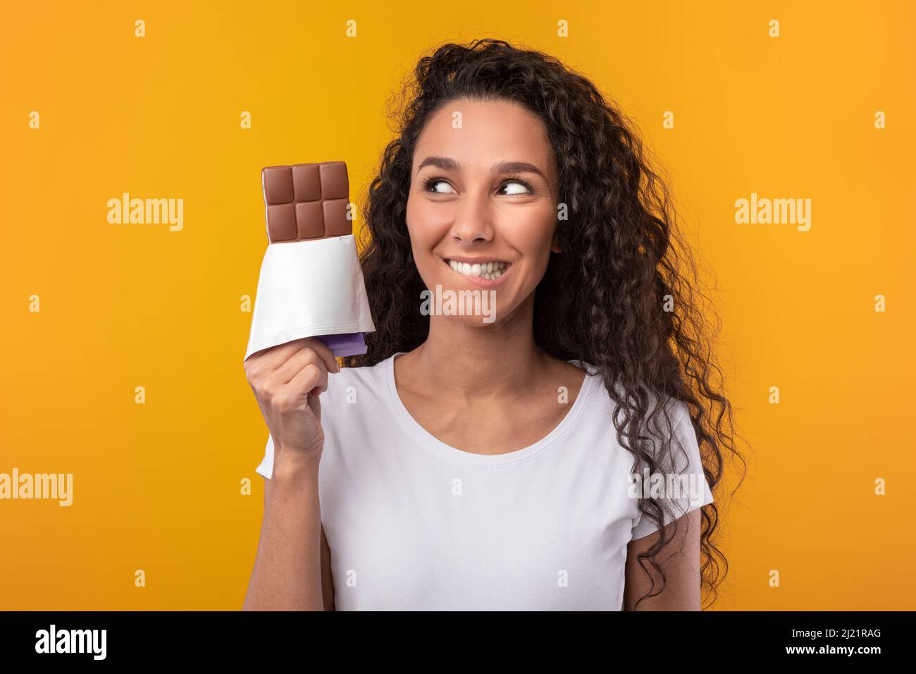 Funny Hungry Lady Holding Chocolate At Studio Stock Photo - Alamy