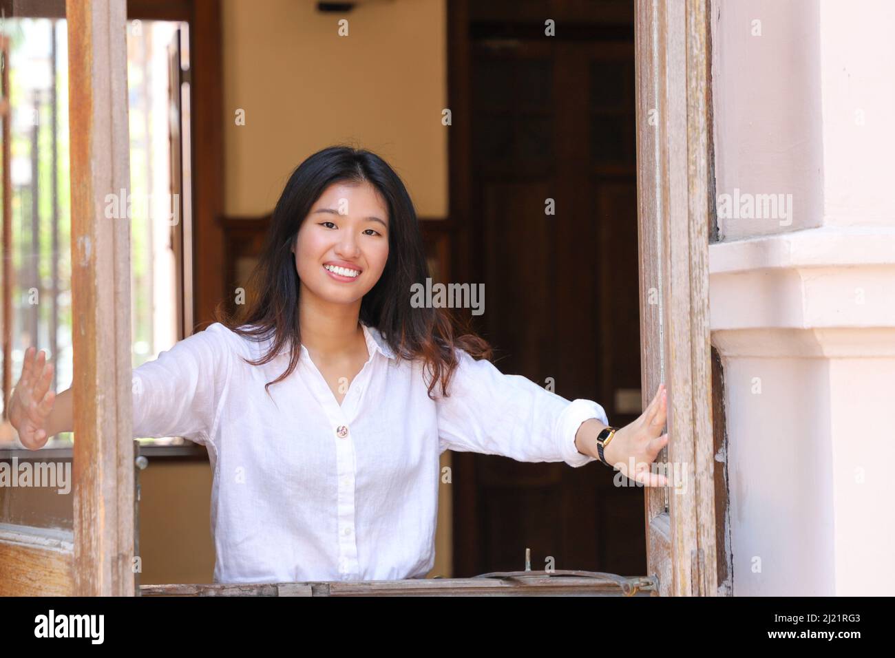 young college female girl student look out through window in old ...