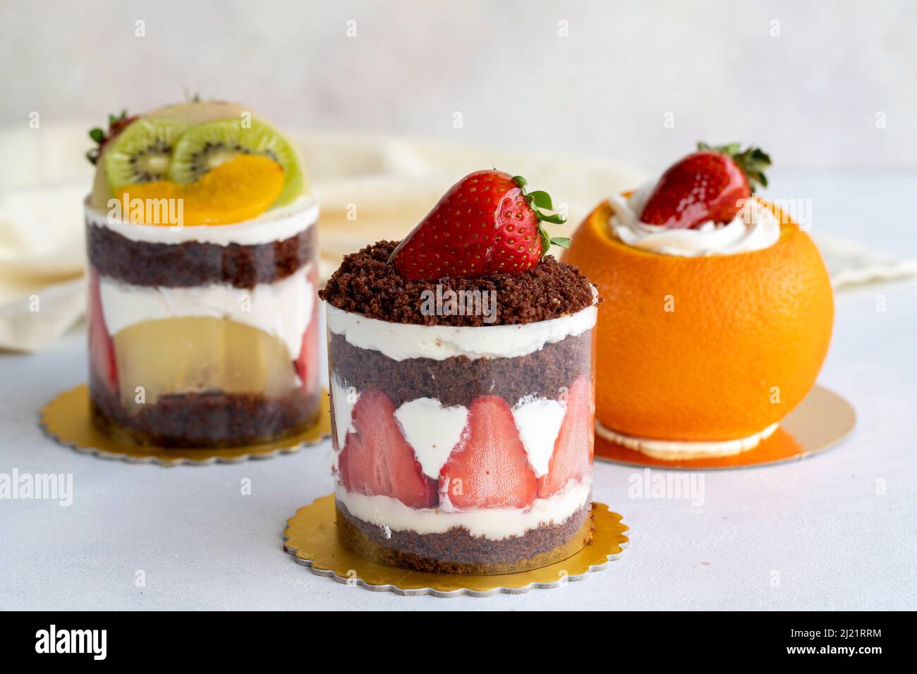 Assorted mini cakes with fruit on a white background. close up Stock ...