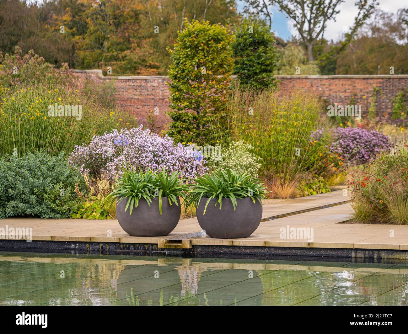 Large round bowl shaped planters placed either side of the rill which ...