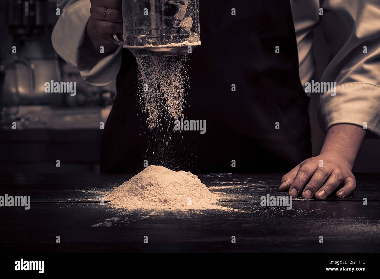 the chef hands are dropping flour over a wooden table Stock Photo - Alamy