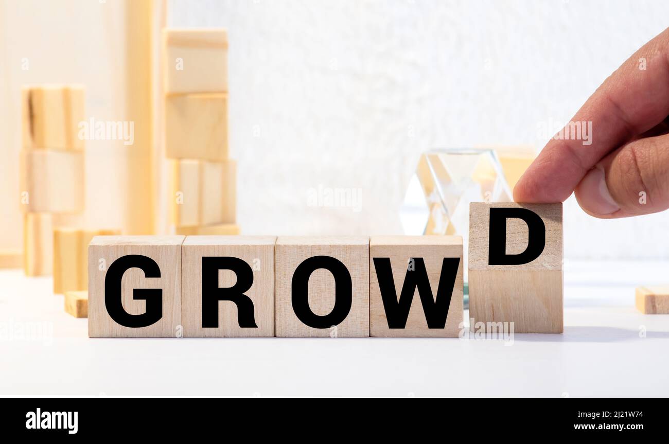 word grow made with wooden blocks on desk with different color graphs ...