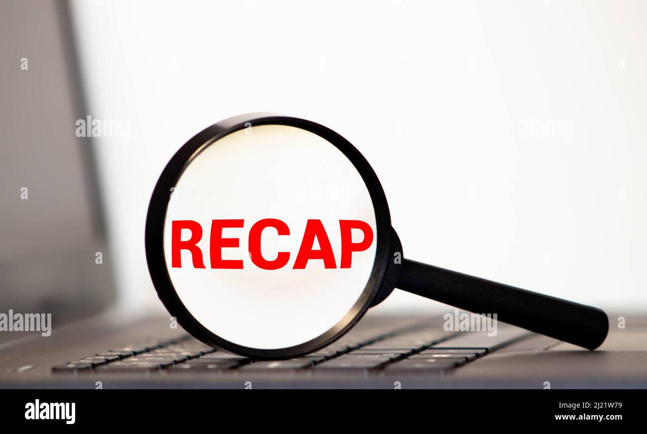 Recap word inscription through magnifying glass on financial documents ...