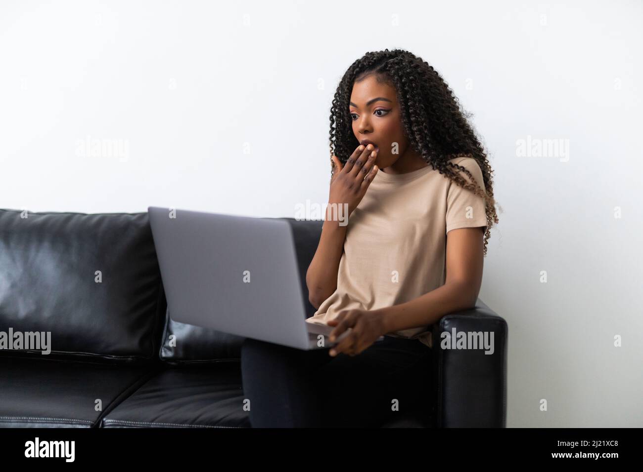 Shocked african woman watching something surprising and unexpected on ...