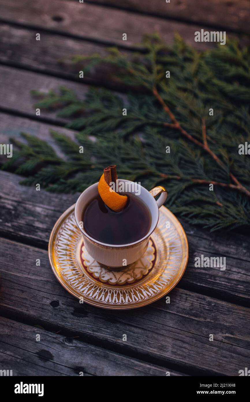 hot toddy teacup with gold pattern, orange cinnamon greenery on wood ...