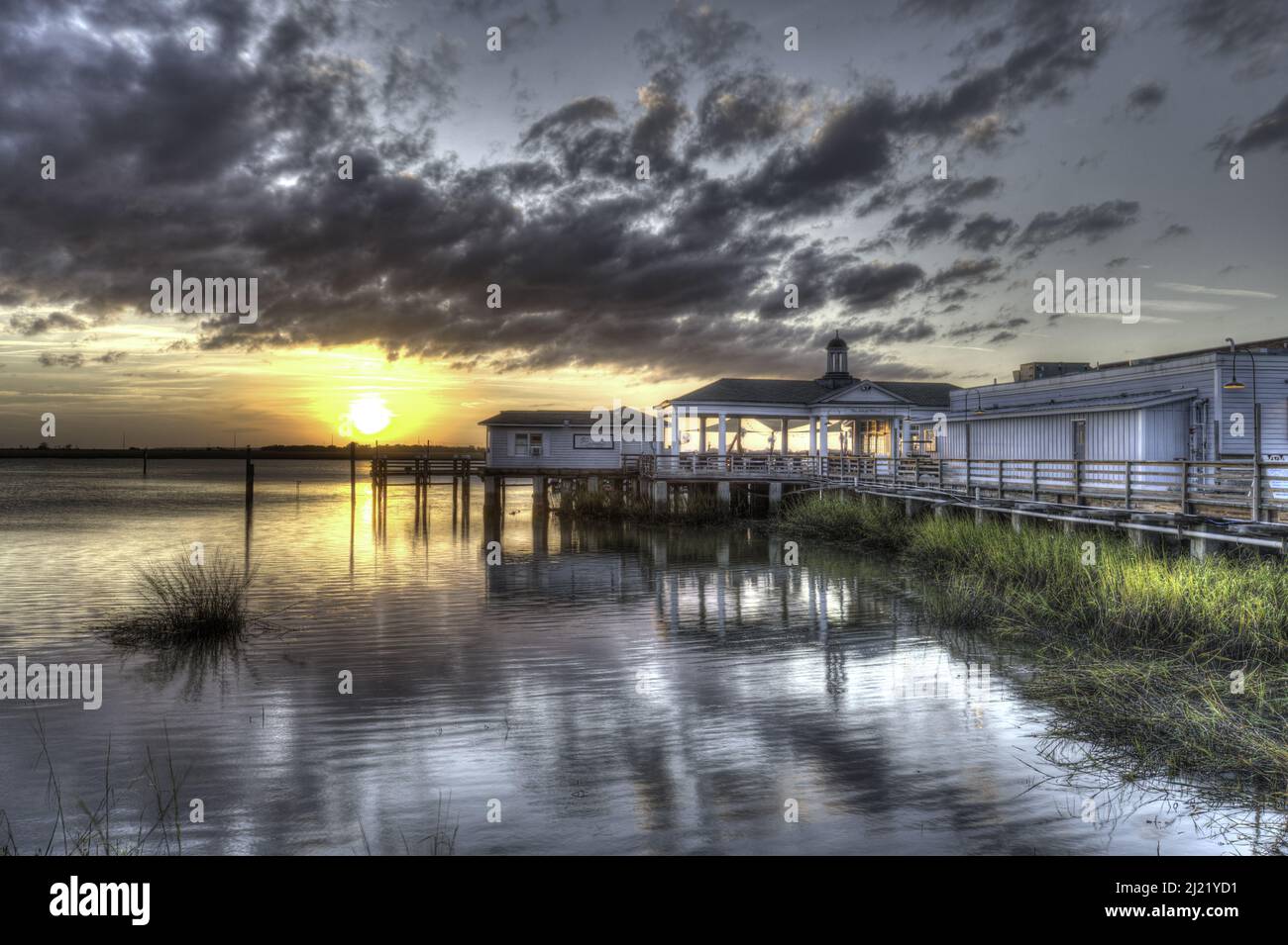 A seaside building against dark sunset sky background reflected in the ...