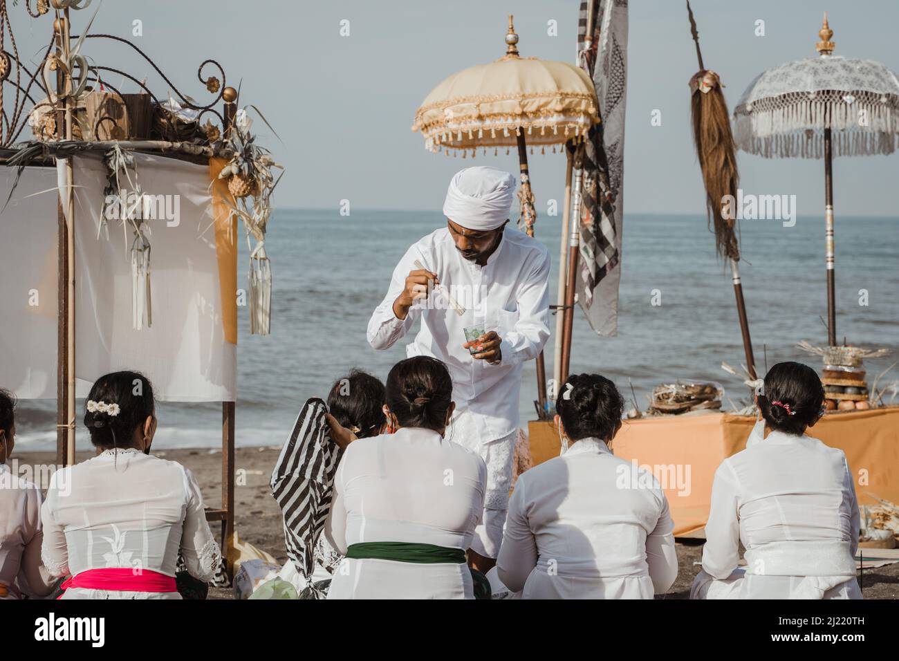 Hindu Priest blessing people with holy water. Balinese Hindus perform ...