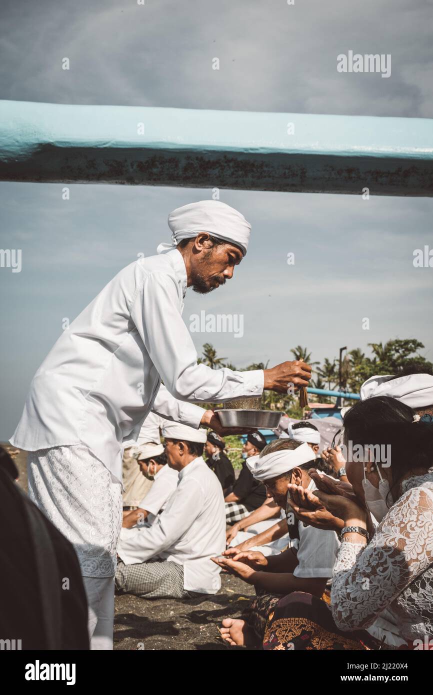 Hindu Priest blessing people with holy water. Balinese Hindus perform ...
