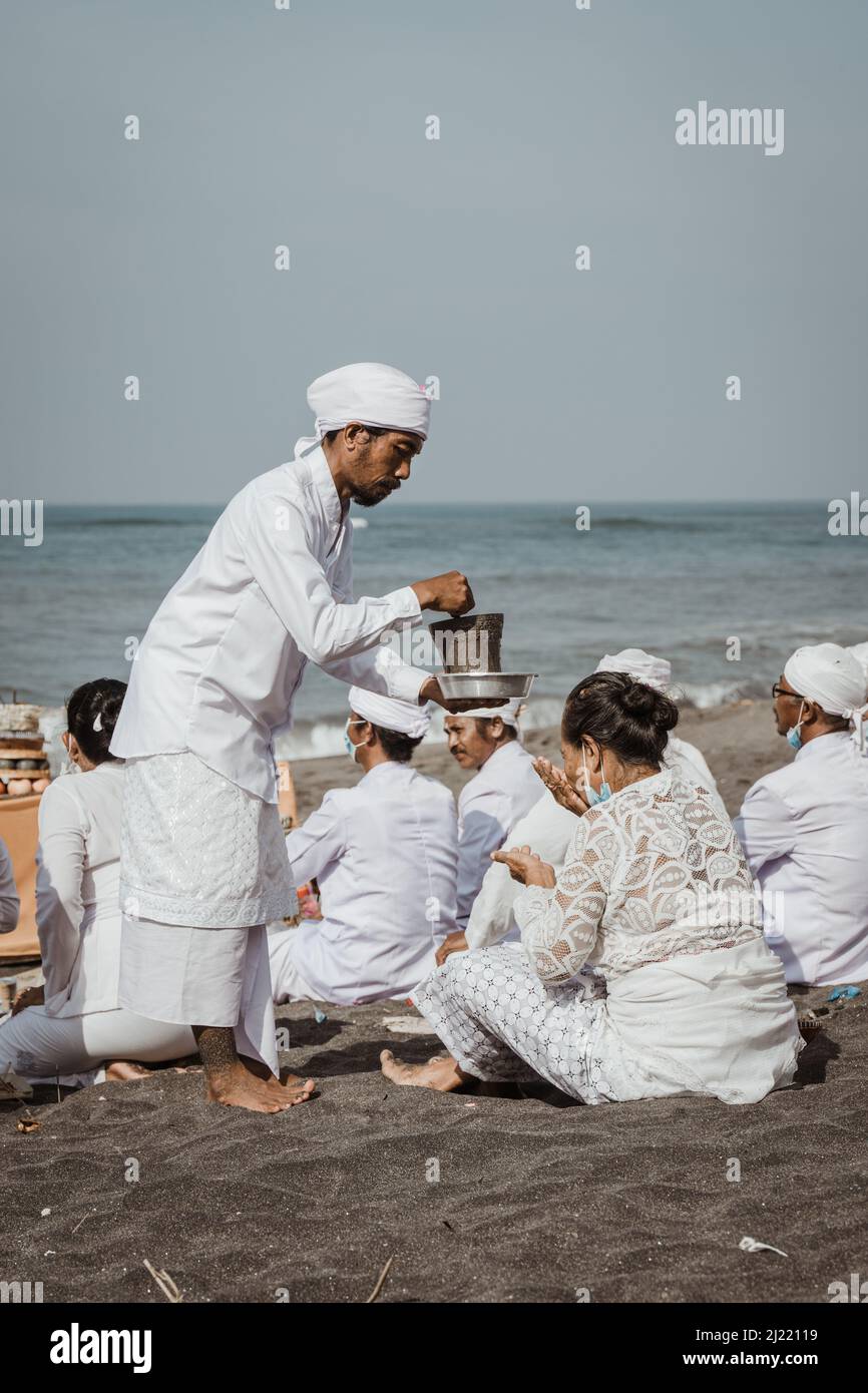 Hindu Priest blessing people with holy water. Balinese Hindus perform ...