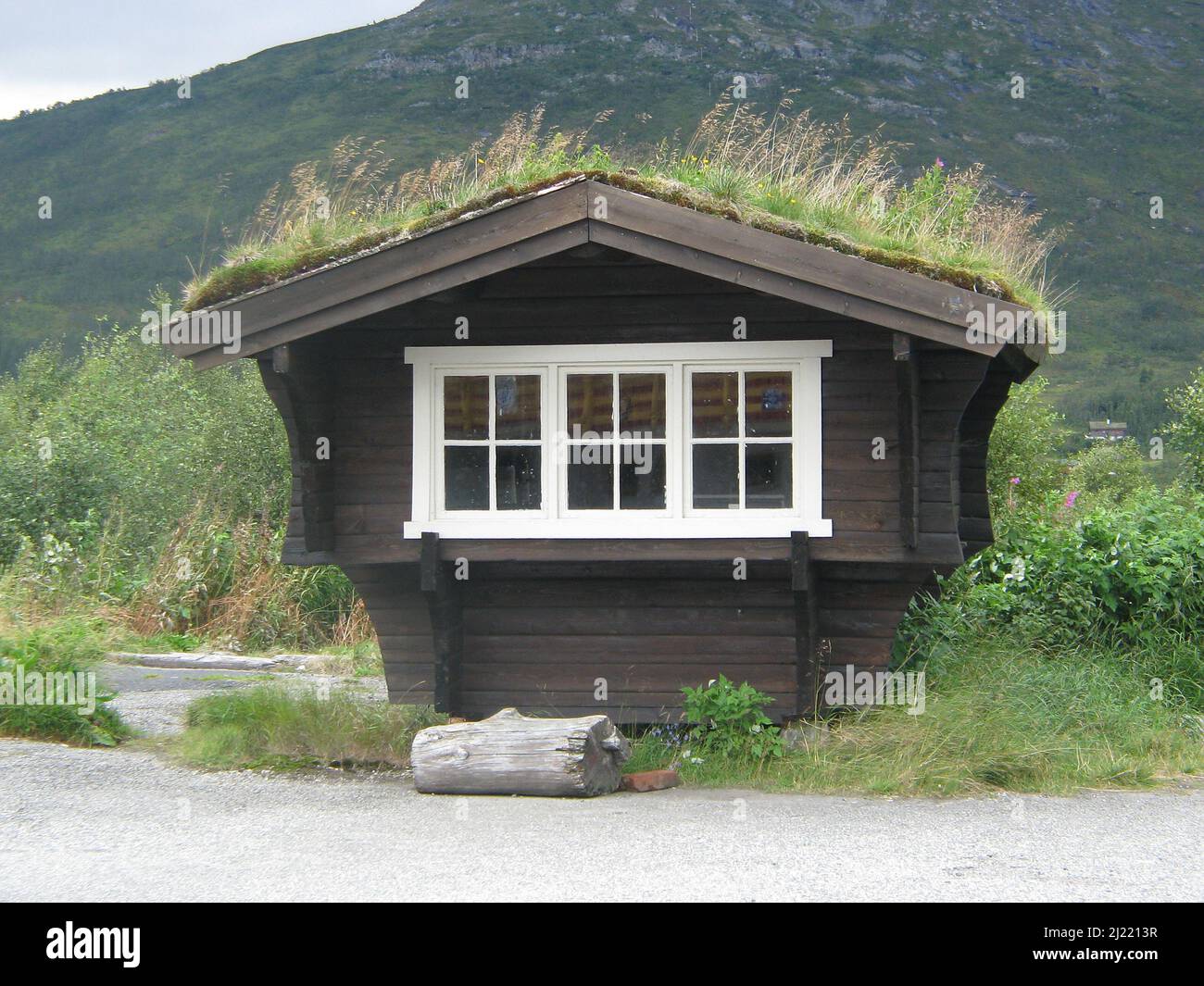 small wooden hut with grass covered roof in the middle of landscape in ...