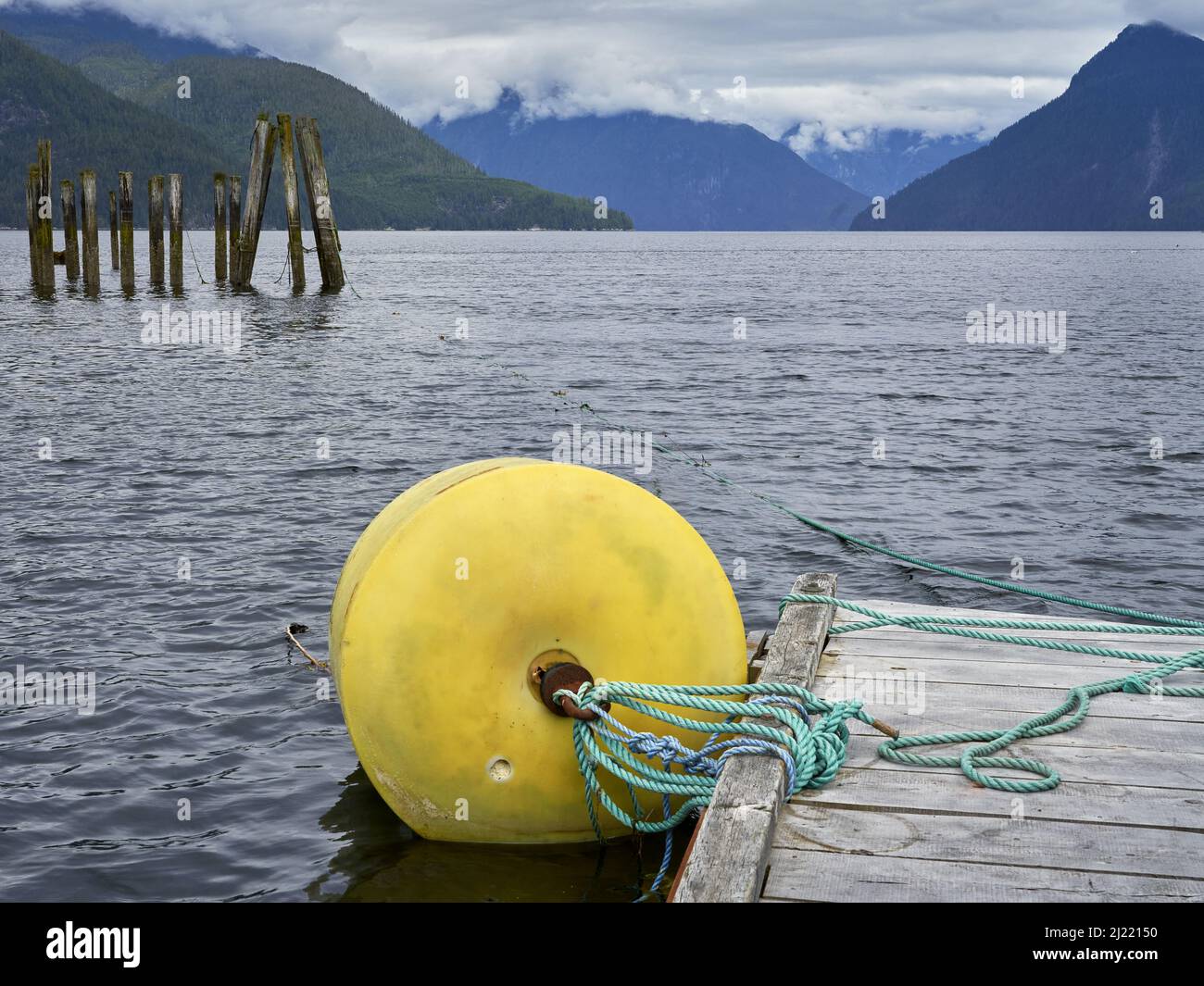 A large bright yellow anchor buoy tied to a float with heavy green rope ...
