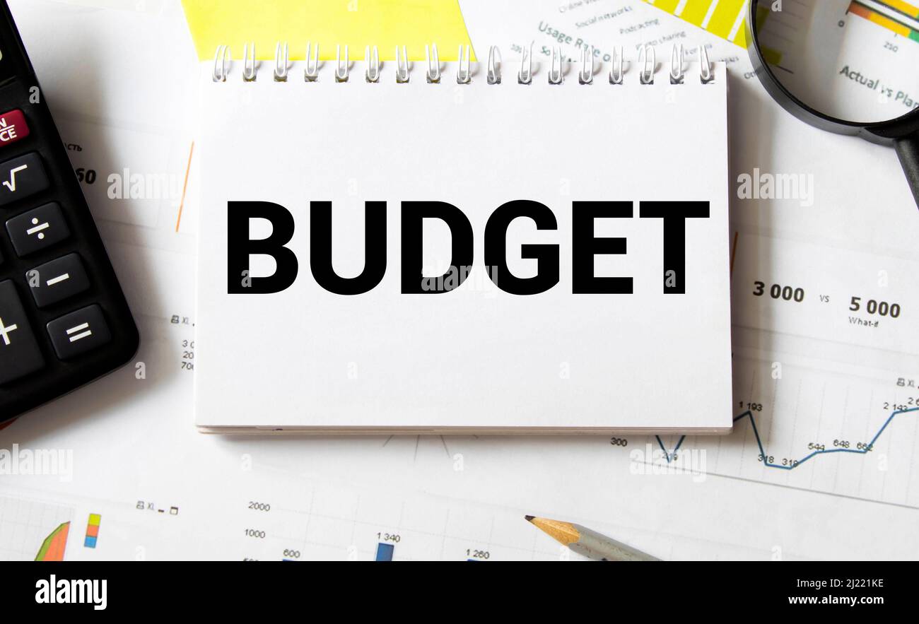 Budget text on paper sheet with magnifying glass on chart, dice ...