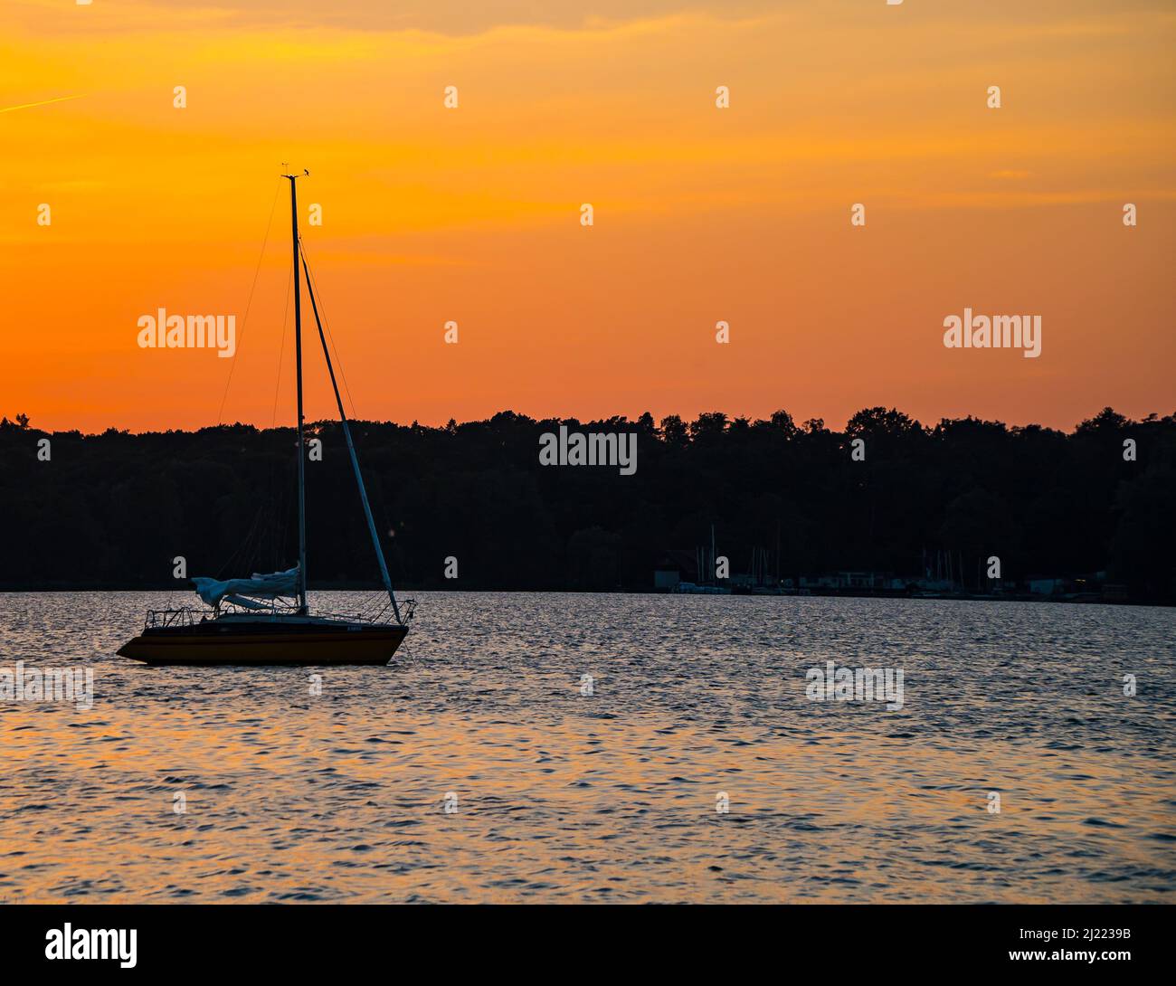 A scenic view of a boat in the wavy water under the sunset sky Stock ...