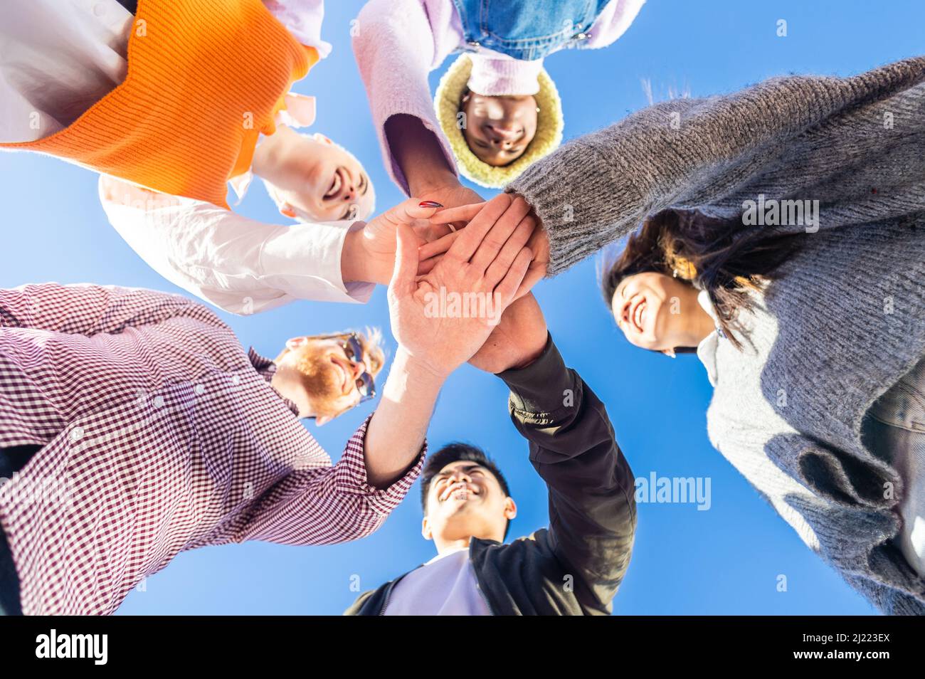 Young people joining their palms in a circle and showing unity and ...